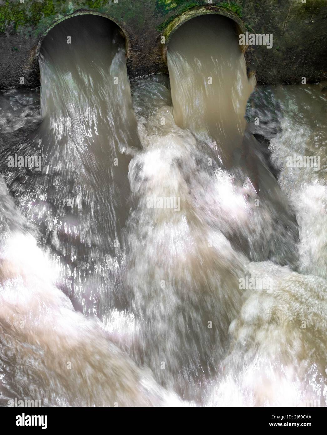 Slow motion shot of water sewage flowing through 2 pipe openings Stock ...