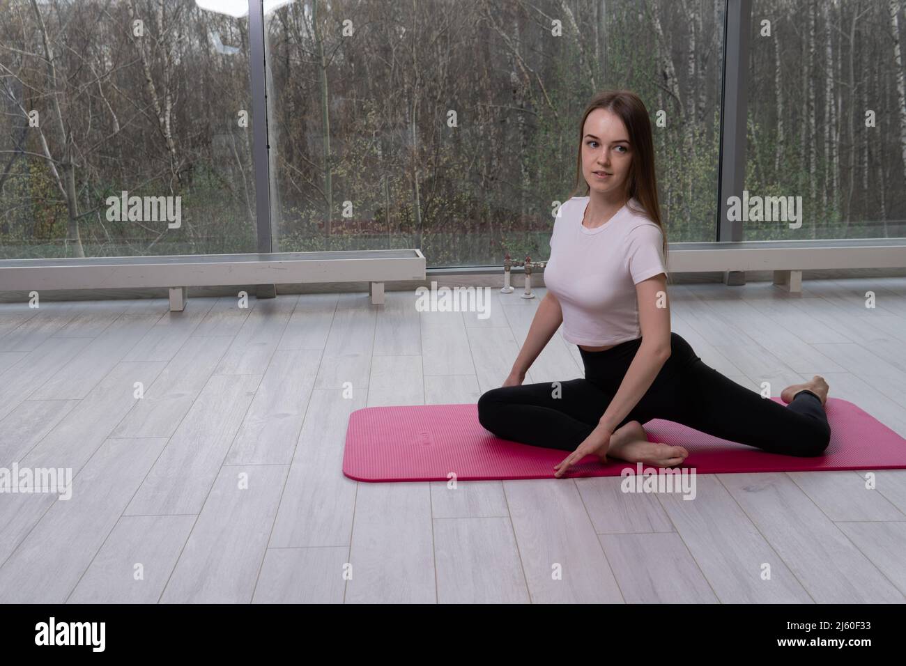 A on mat girl in fitness exercises shows a a club fitness red strength ...