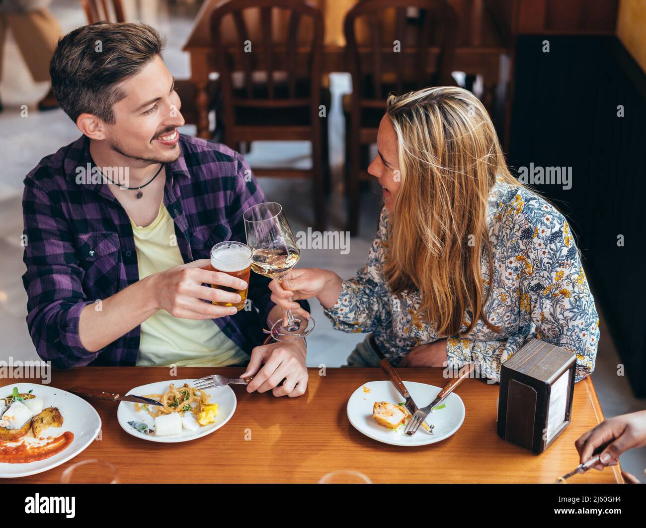 a couple toasting seated at a table in a restaurant Stock Photo - Alamy