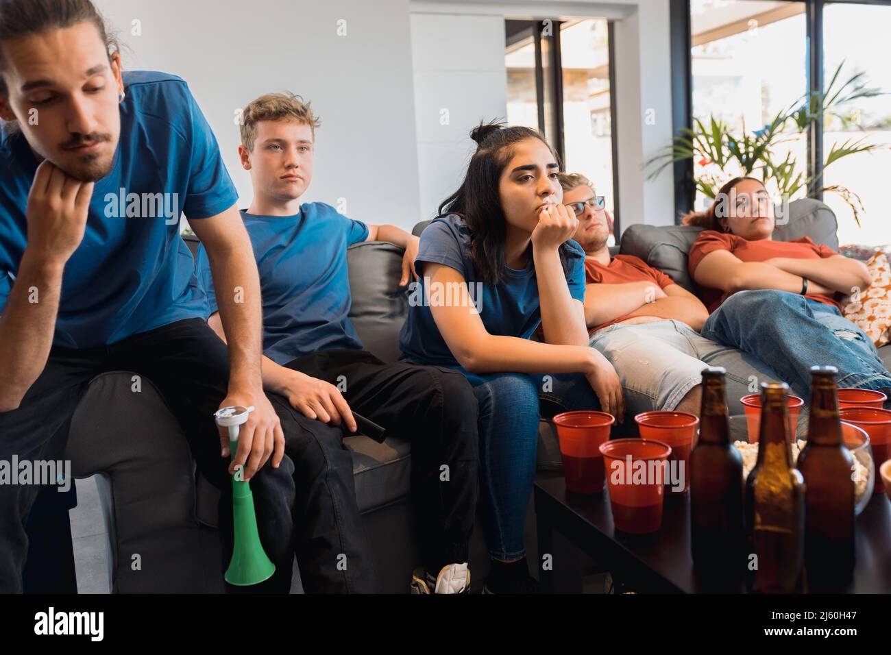 group of friends disappointed with their team, watching a football ...