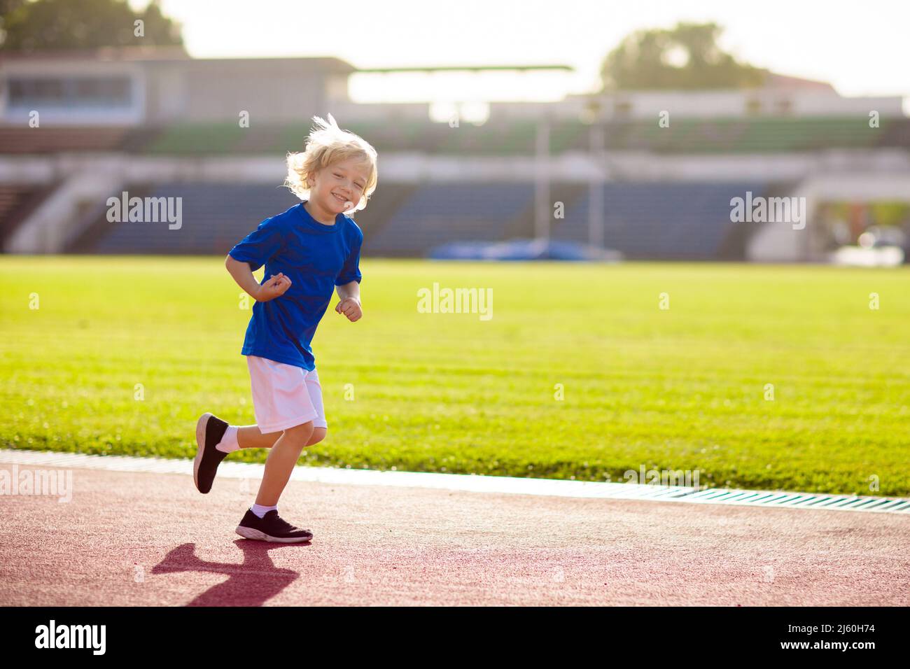 Child running in stadium. Kids run on outdoor track. Healthy sport ...