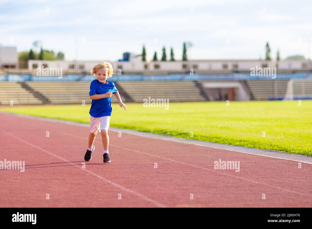 Child running in stadium. Kids run on outdoor track. Healthy sport ...