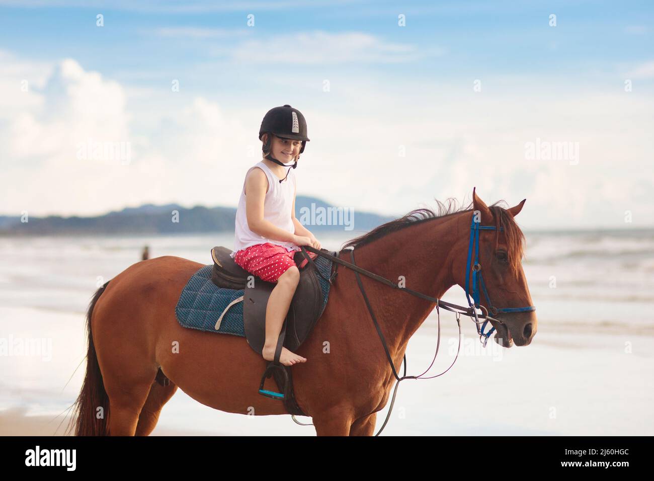 Kids riding horse on beach. Children ride horses. Cute little girl on ...