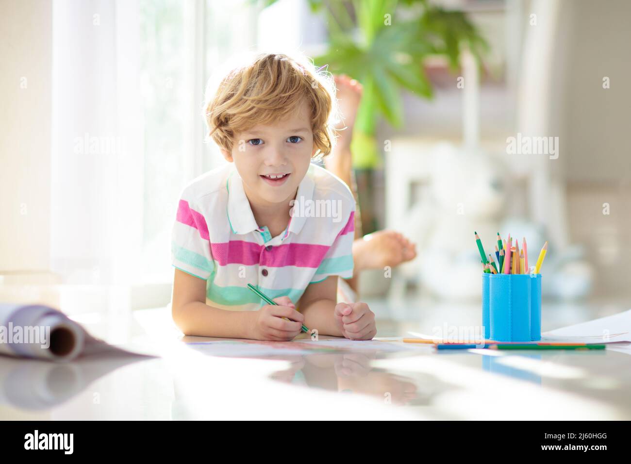 Child drawing lying on the floor. Kid painting rainbow. Online remote ...