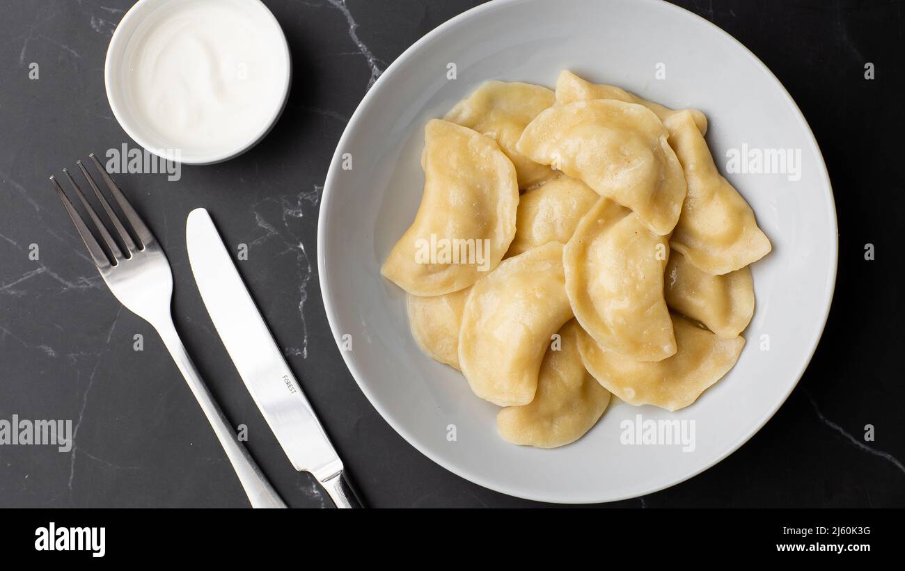 Traditional ukrainian dish vareniki served in a bowl with sour cream ...