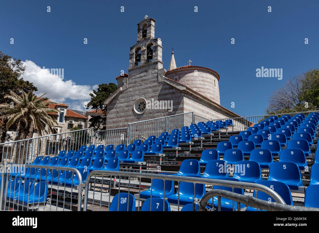 A seating stand of blue plastic chairs that are in rows goinf upwards ...