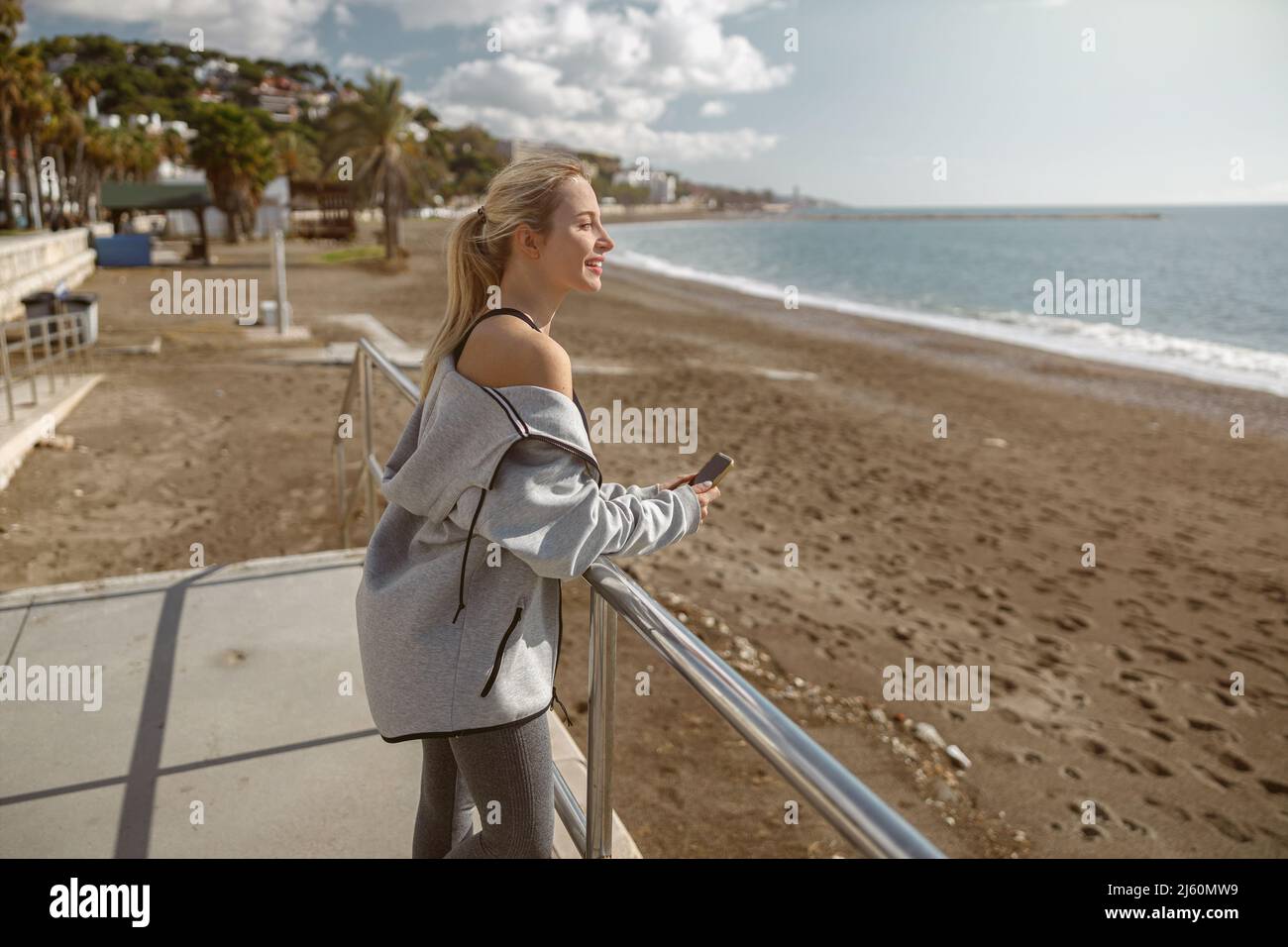 Pretty woman relaxing after workout at seashore Stock Photo - Alamy