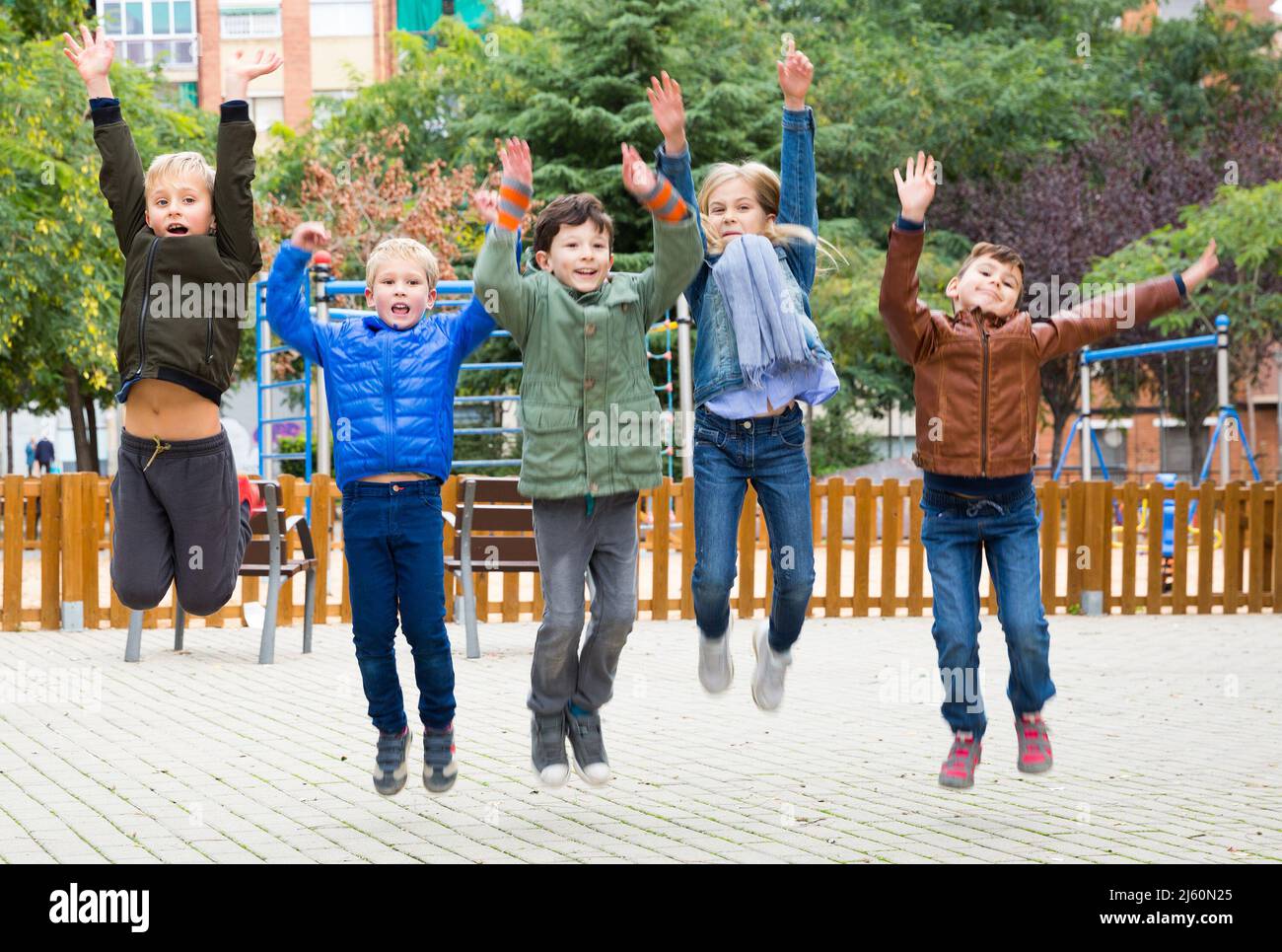 Happy kids jump and play outside Stock Photo - Alamy