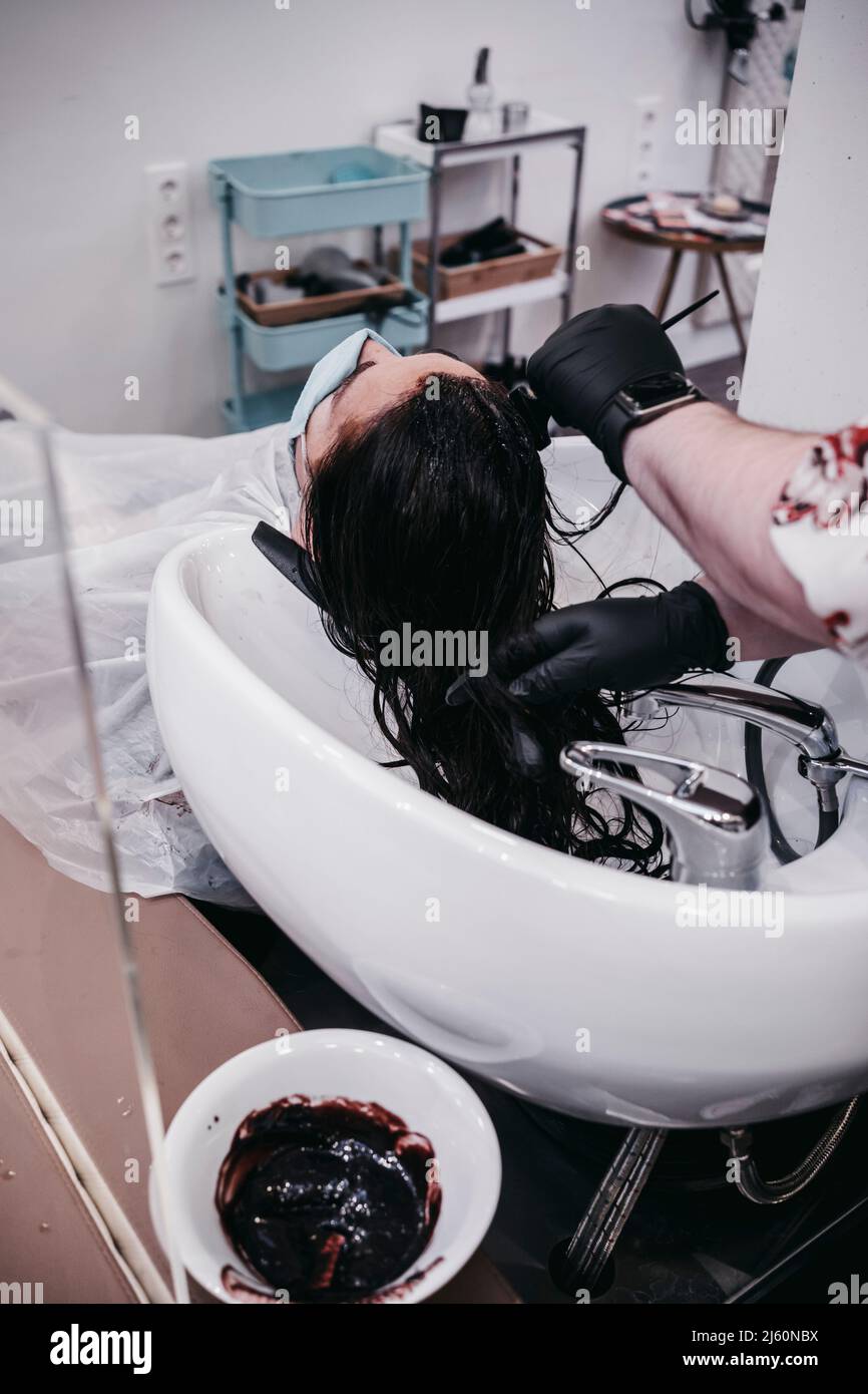 hairstylist with hair dye and hair dye brush at salon Stock Photo - Alamy