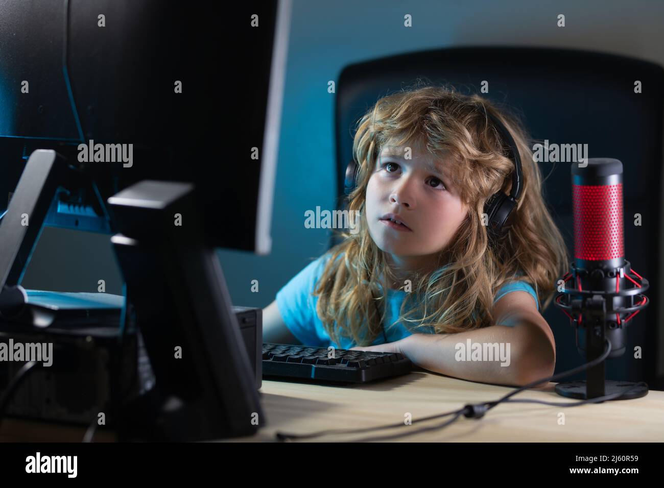 A little boy child uses a desktop at night, a child with computer ...