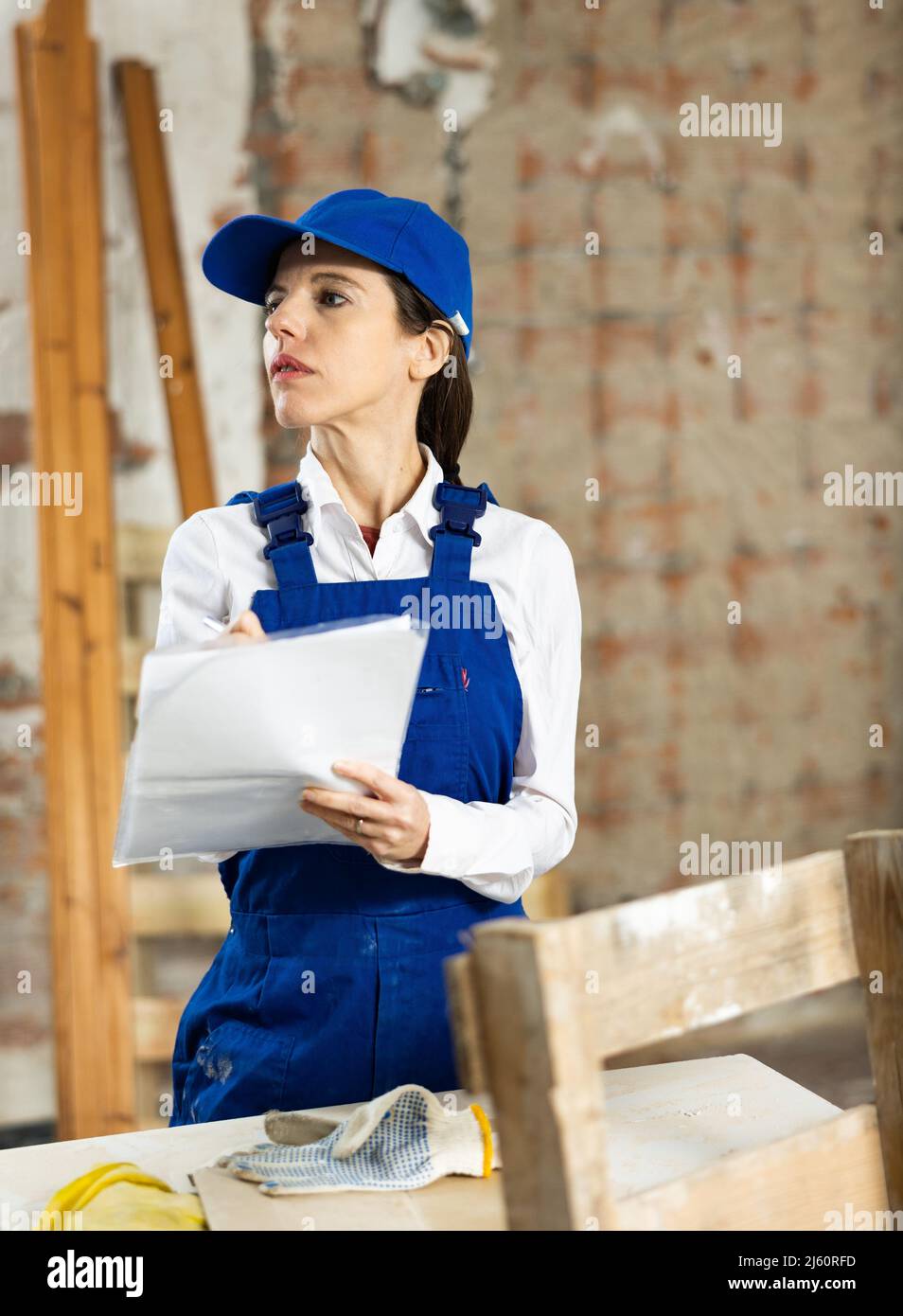 Female contractor taking notes while planning building renovation Stock ...