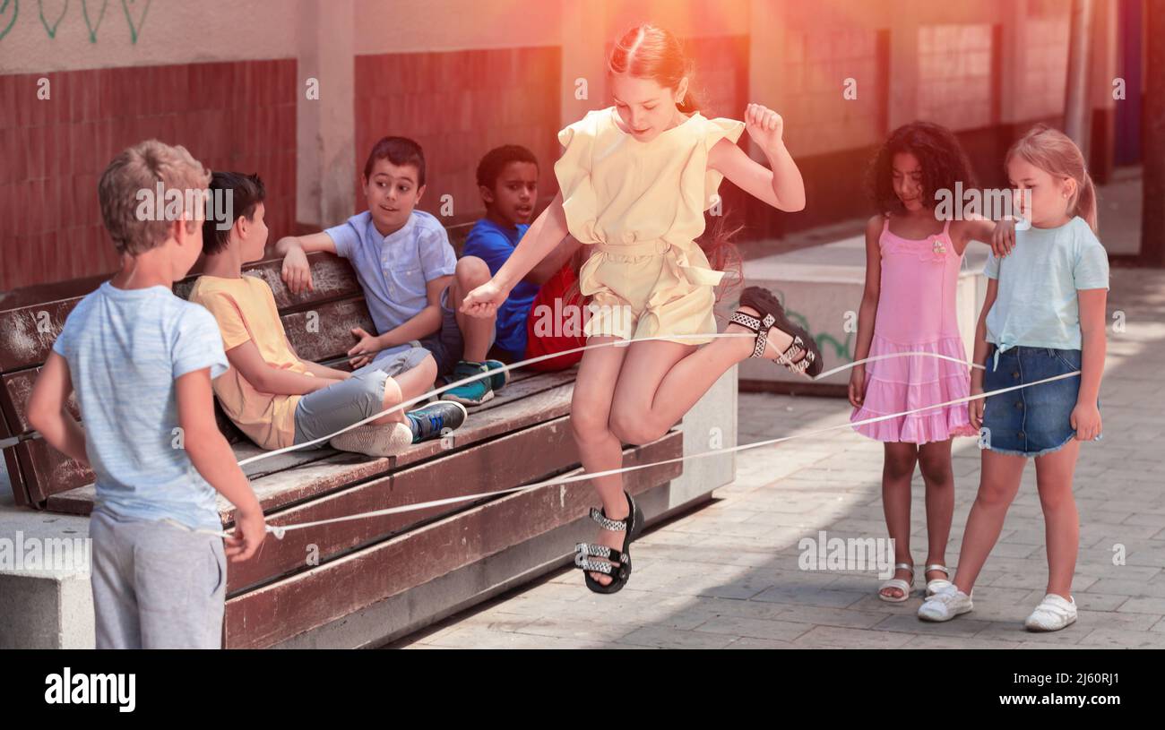 Happy little girl jumping game by rubber band with friends Stock Photo ...