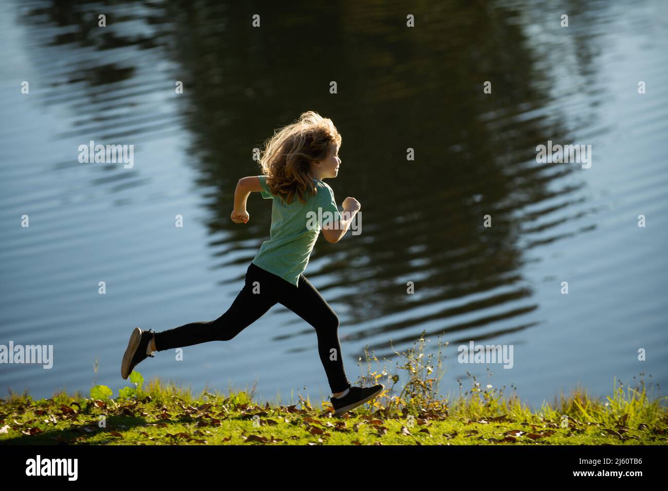 Kid running on lake. Happy child run in lake on summer vacation. Sporty ...