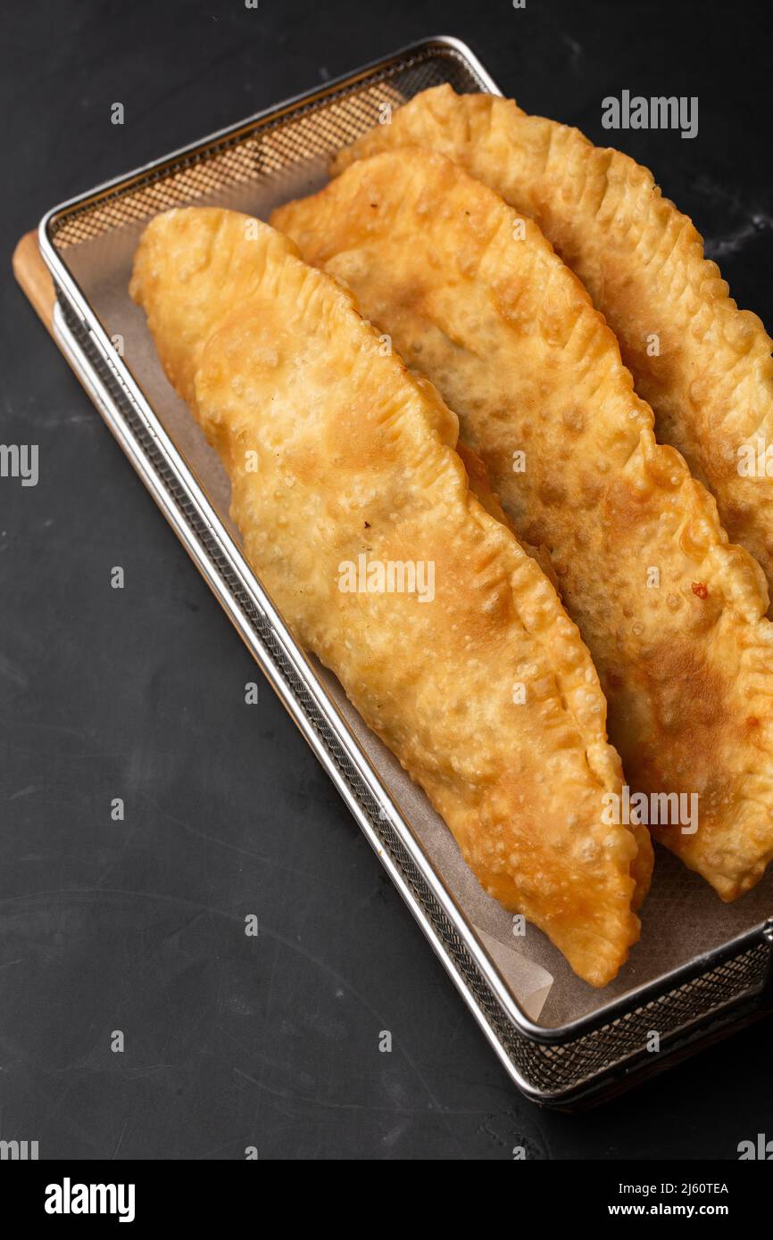 Uzbek eastern Tatar cuisine, cheburek on a black board. Cheburek ...