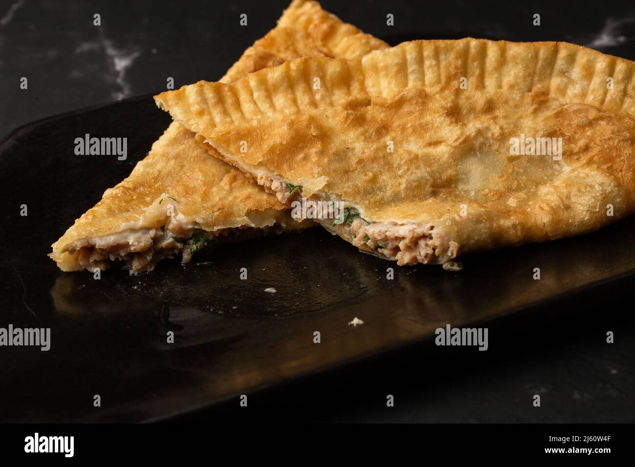 Uzbek eastern Tatar cuisine, cheburek on a black board. Cheburek ...