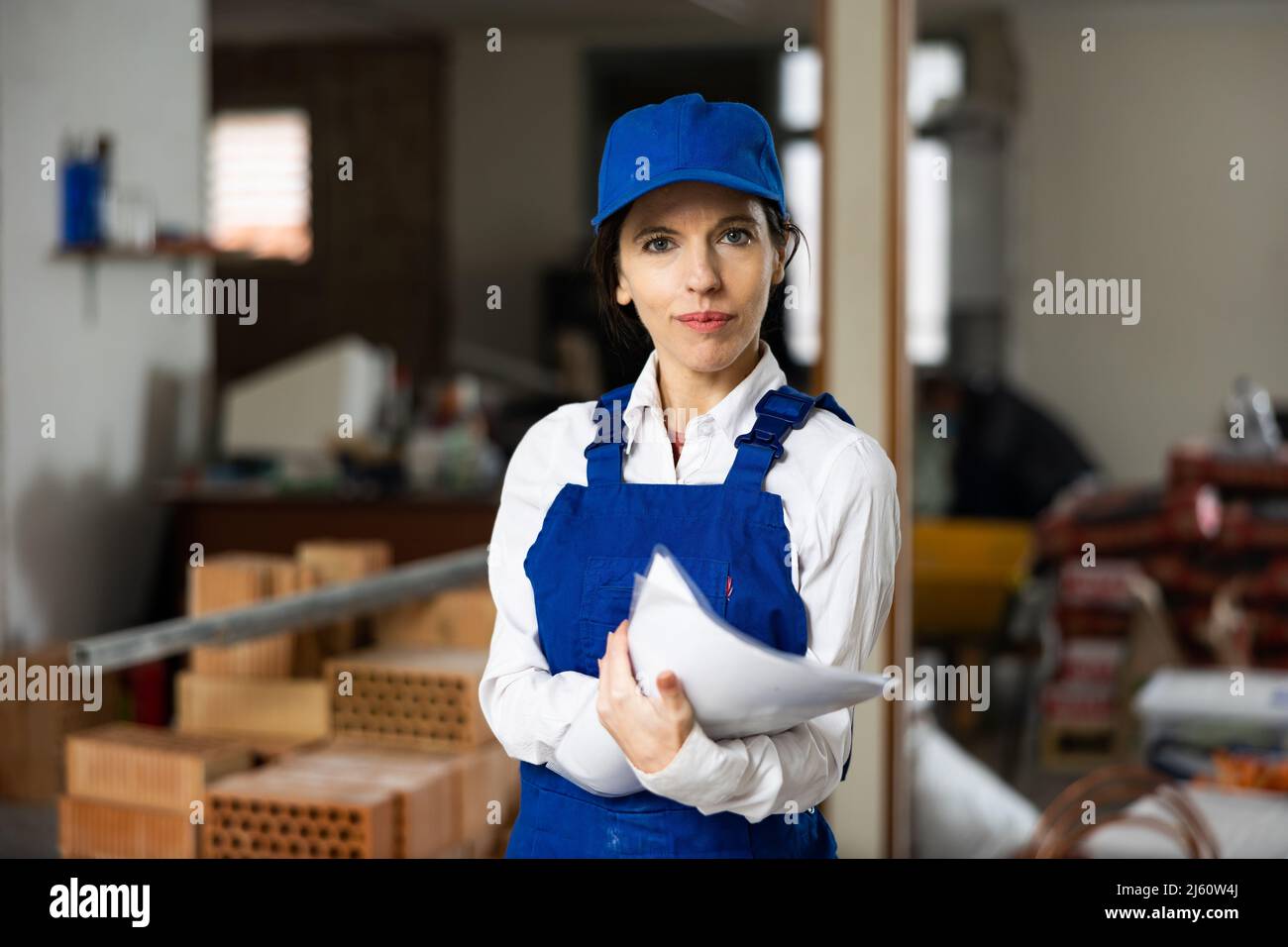 Positive female civil engineer taking notes while checking indoor ...