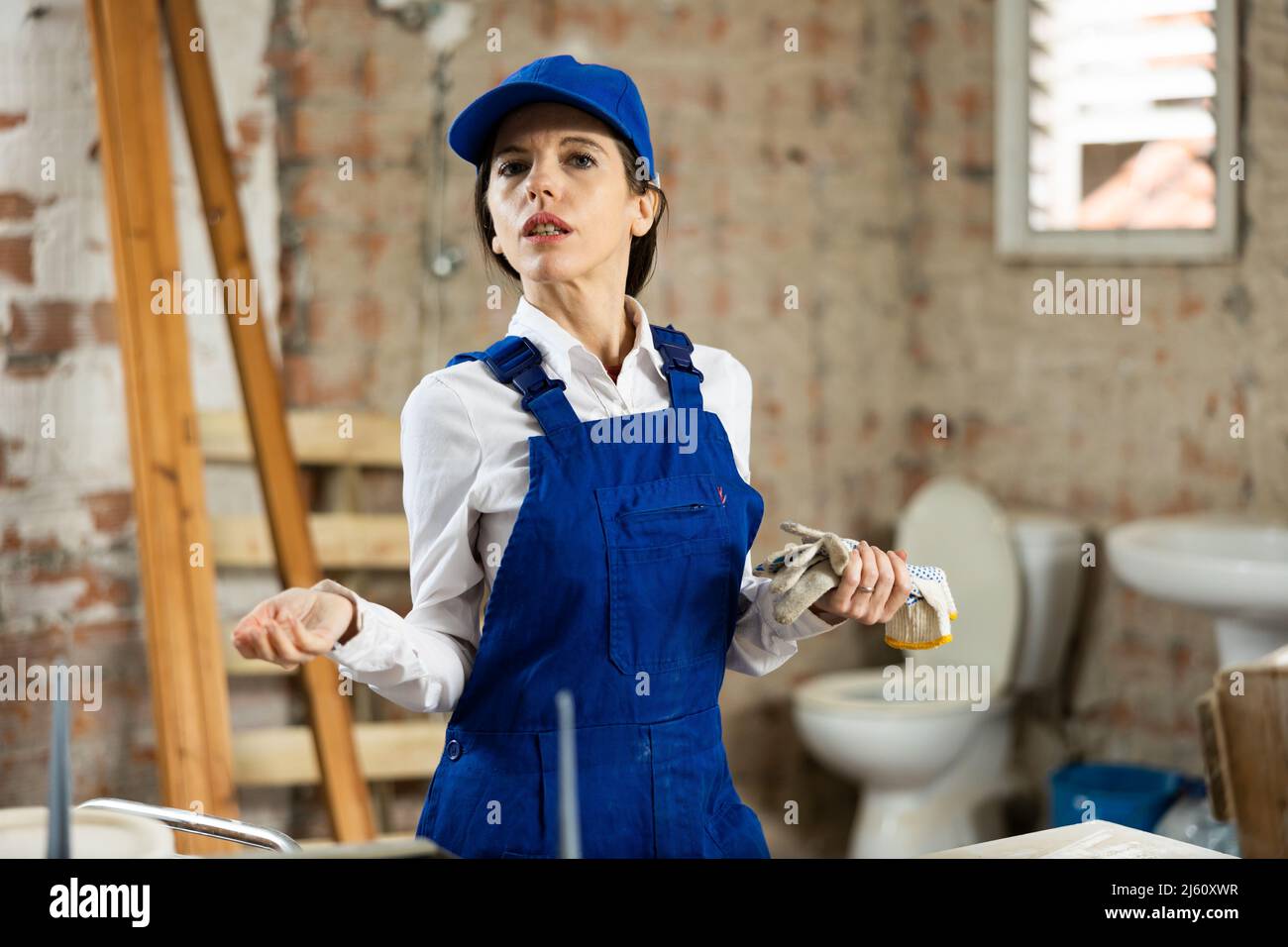 Woman construction worker posing inside house under renovation Stock ...