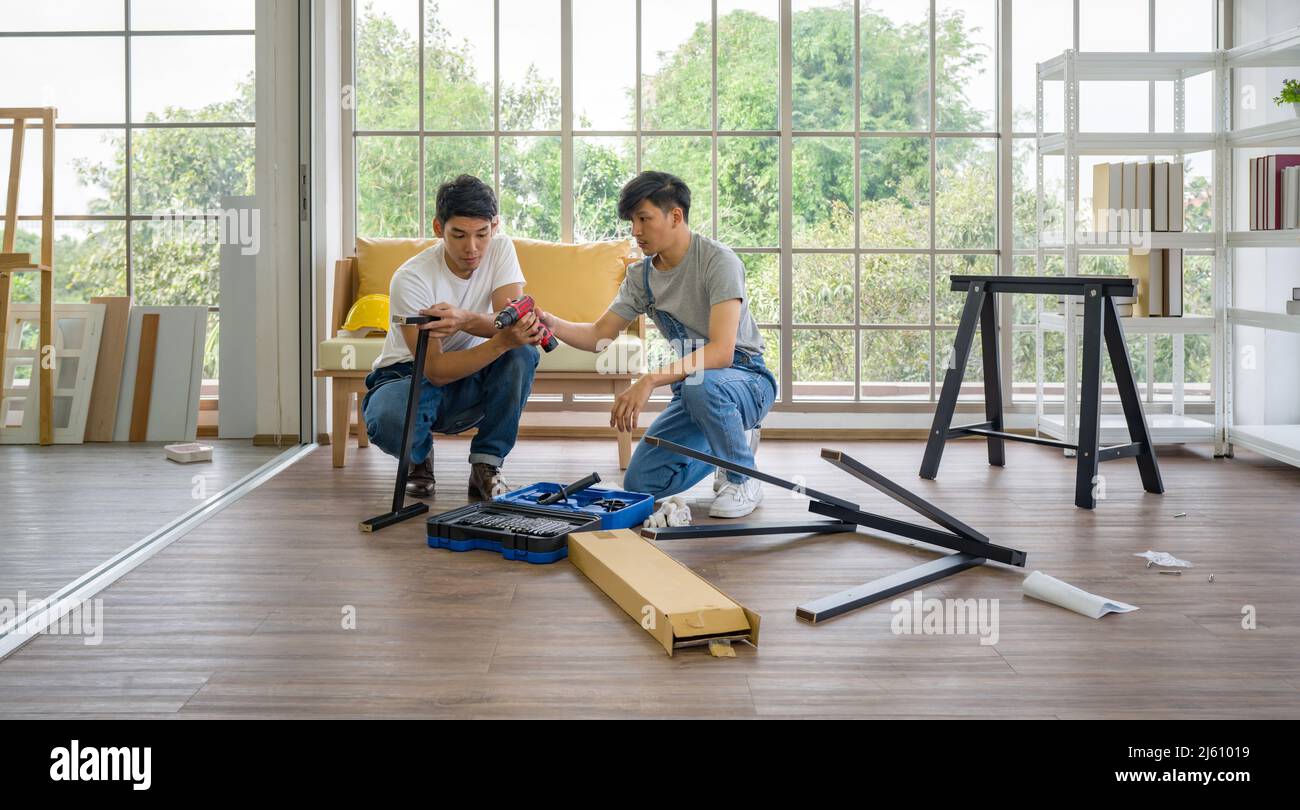 Two asian carpenters installing wooden bench in new house. House ...