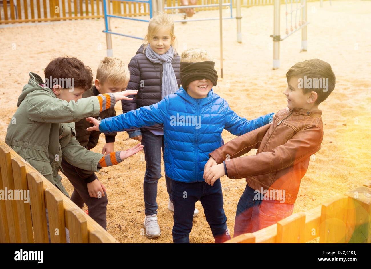 Happy children playing blind man bluff Stock Photo - Alamy