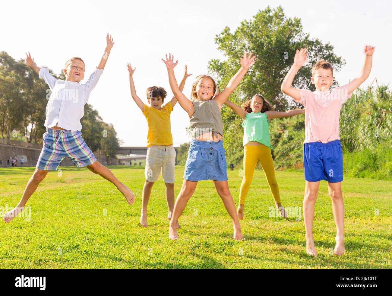 Children jumping and raising hands up Stock Photo - Alamy