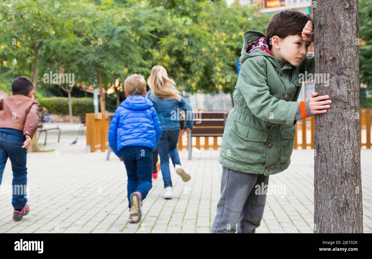 Boy playing hide and seek with children Stock Photo - Alamy