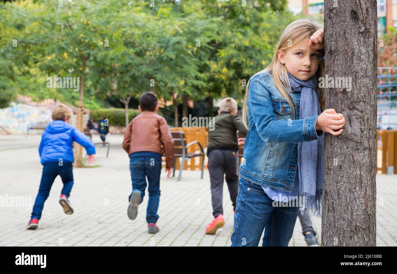 Girl playing hide and seek with friends Stock Photo - Alamy