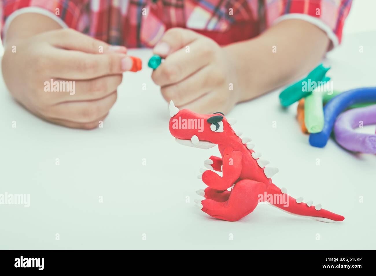 Child playing and creating toys from play dough. Child molding model ...