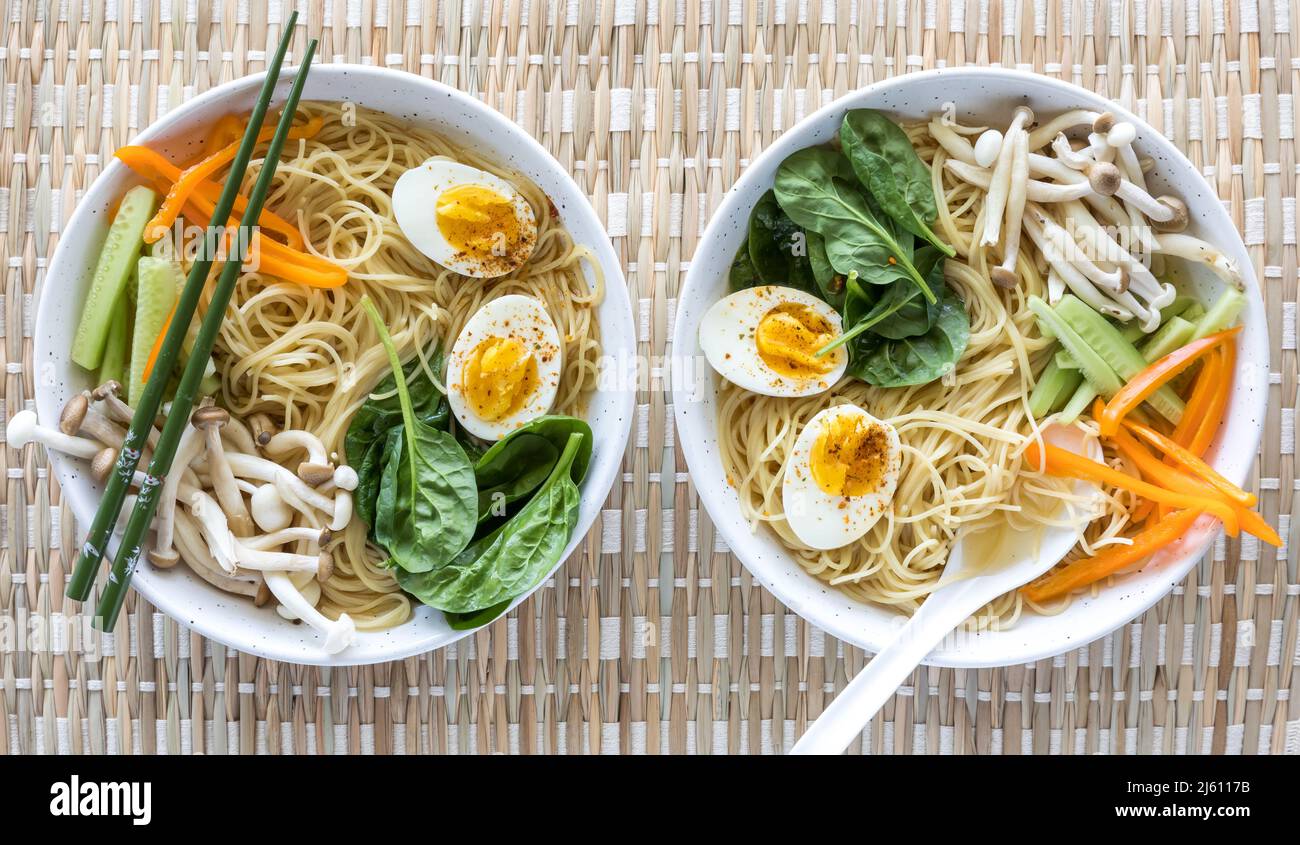 Top down view of two bowls of freshly made pho soup, ready for eating ...