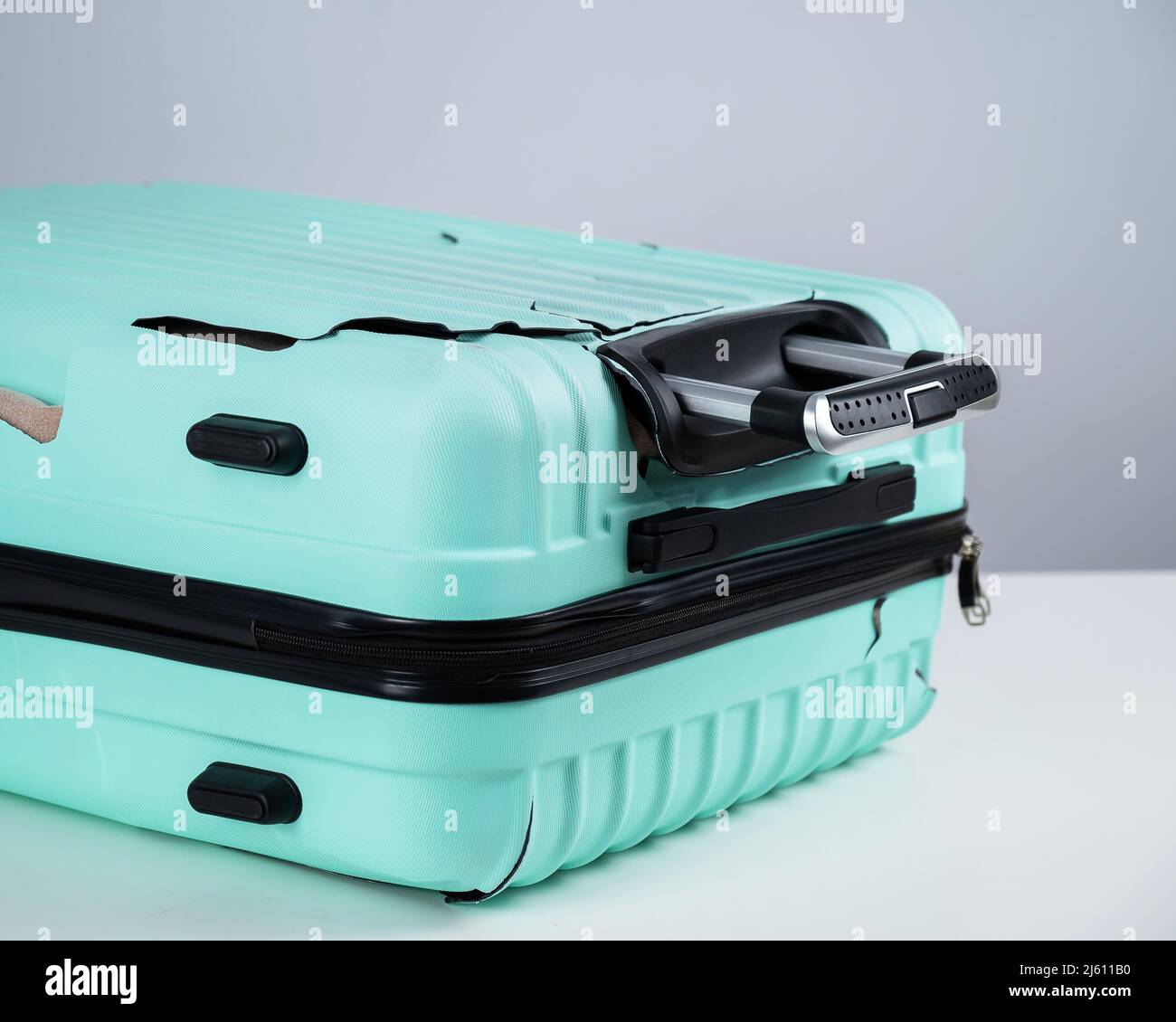 Broken plastic mint suitcase on a white background Stock Photo - Alamy