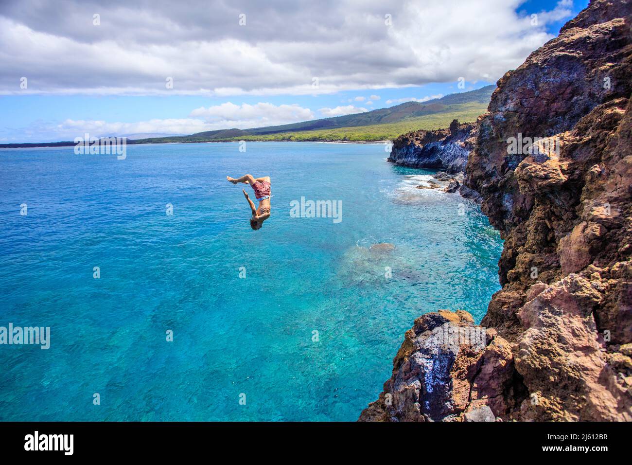 Cliff diver leaping off the south side of La Perouse Bay, Maui, Hawaii ...