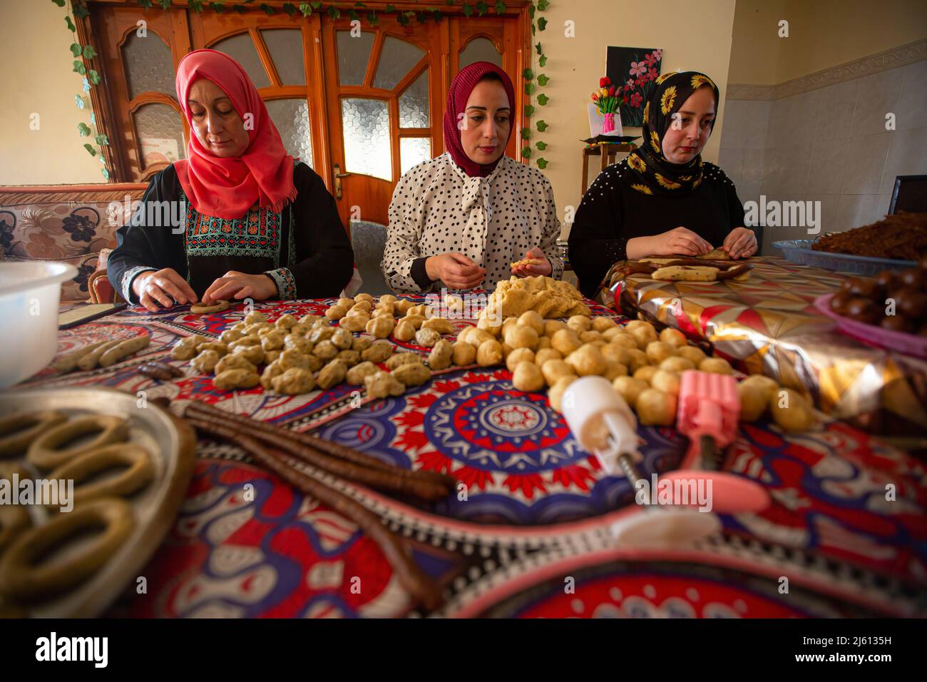A Palestinian family makes traditional sweets at their home in the ...