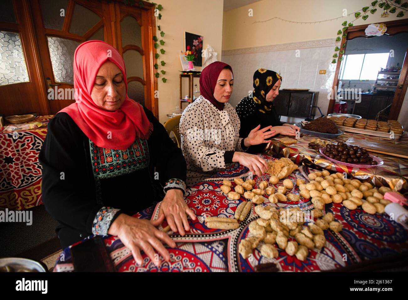 A Palestinian family makes traditional sweets at their home in the ...