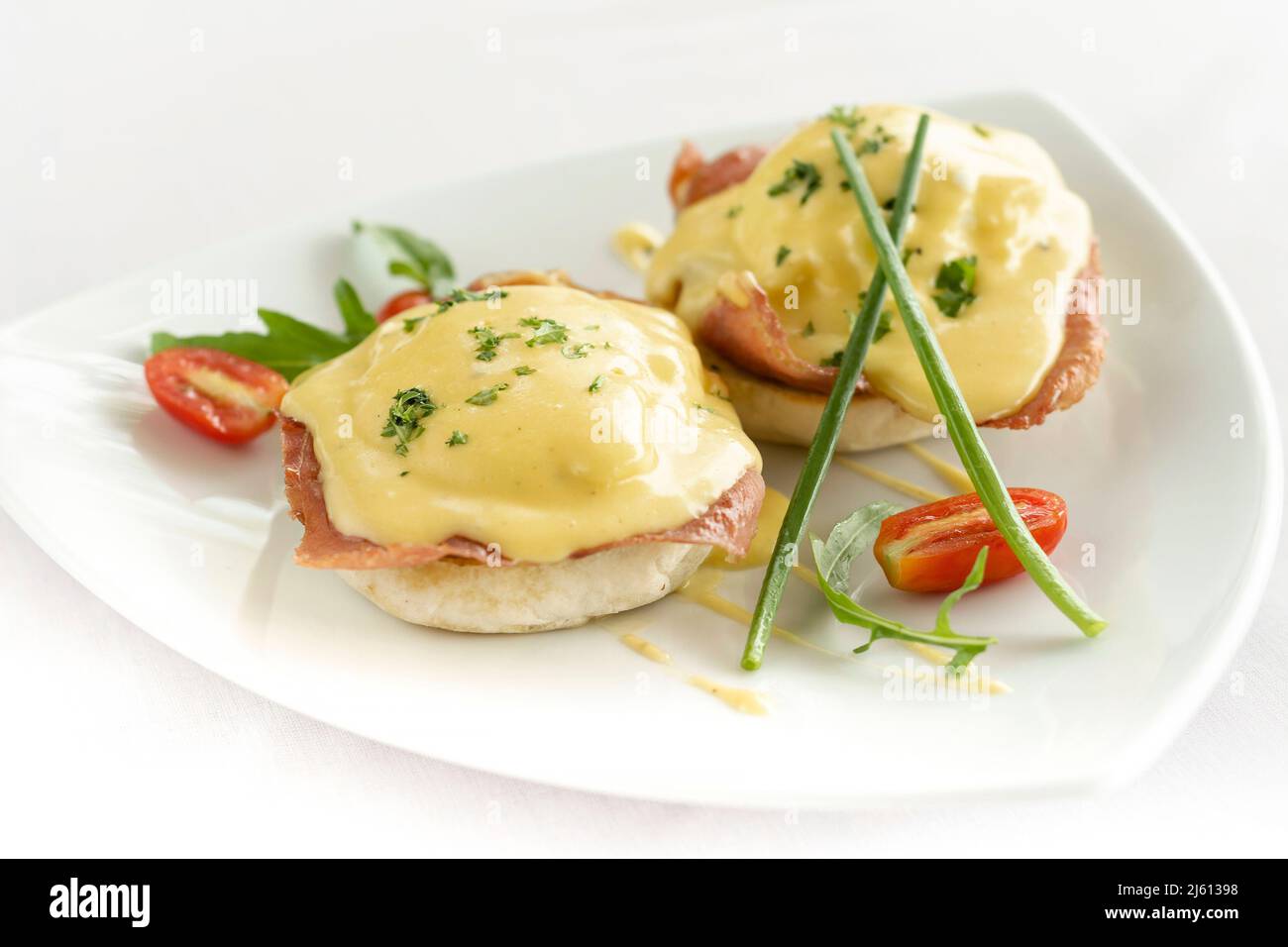eggs benedict breakfast with ham and hollandaise sauce on white ...