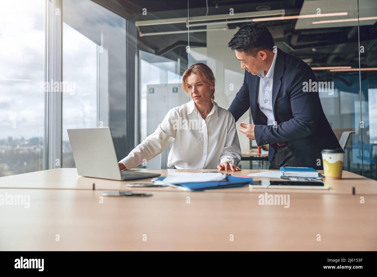 Two confident employees. Working with smile on face together using ...
