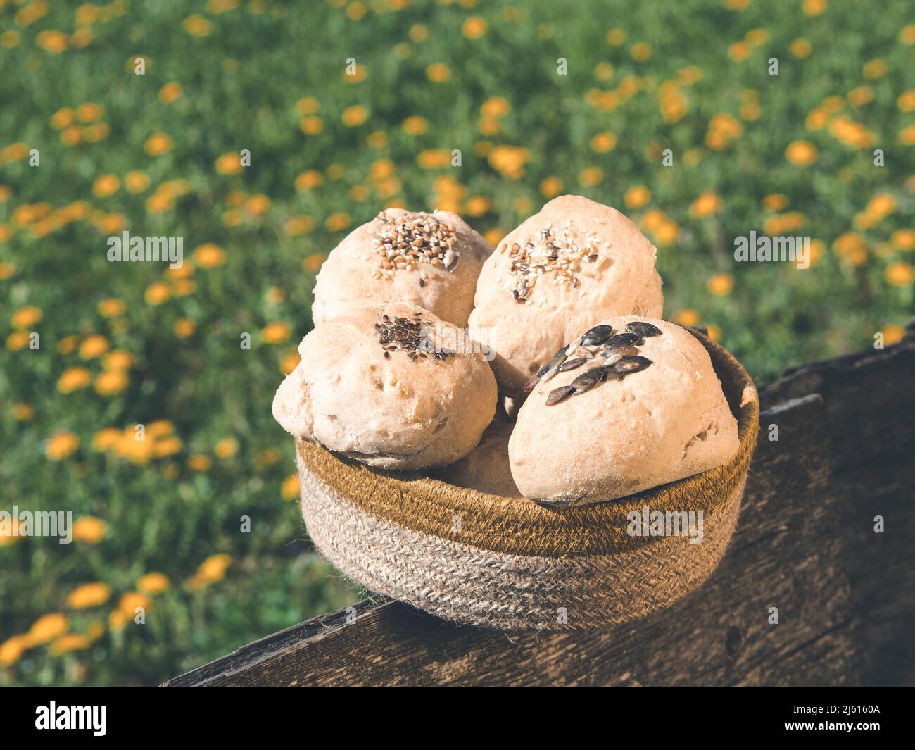 rustic crusty buns decorated with sesame and pumpkin seeds on garden ...