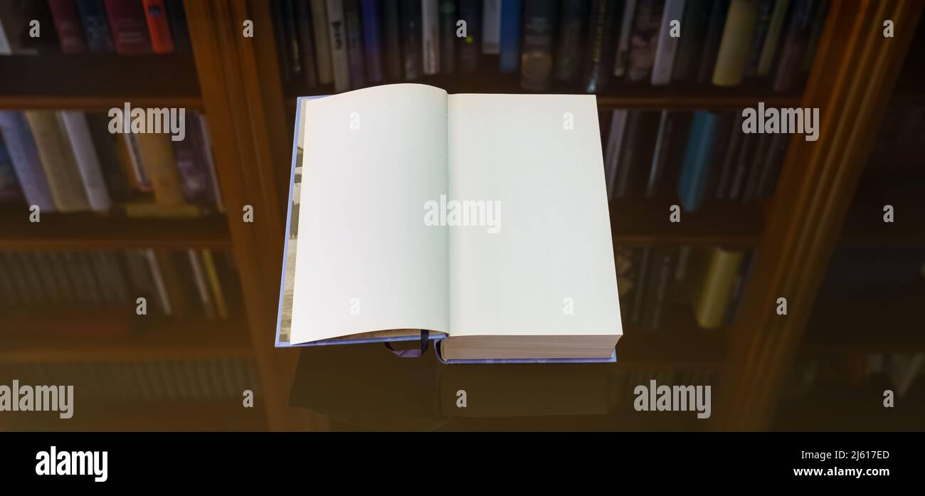 Blank open book to write your text, on a glass table with a reflection ...