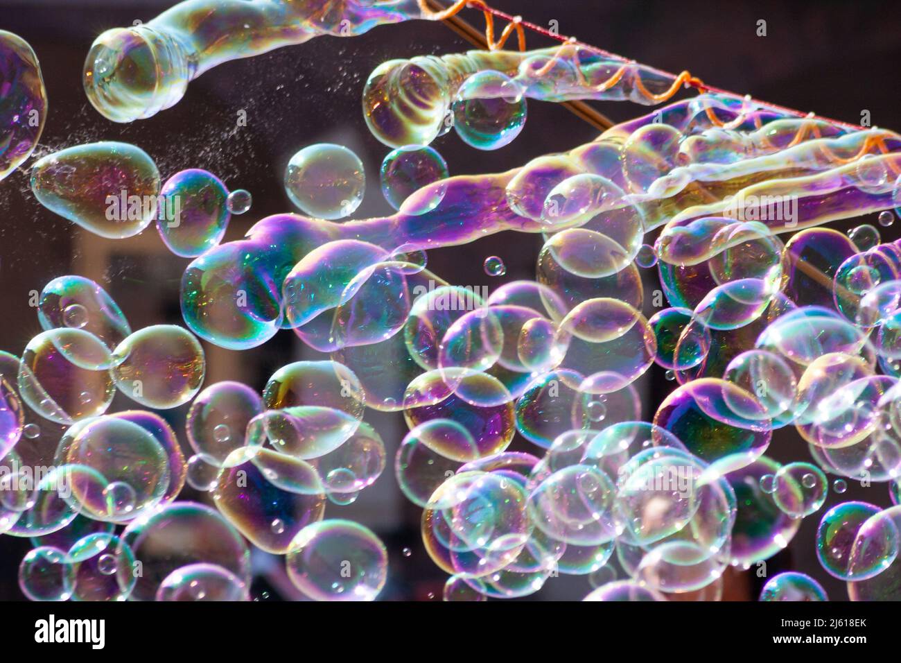 Gigantic soap bubbles shimmer and glimmer in the sun as colorful kids ...