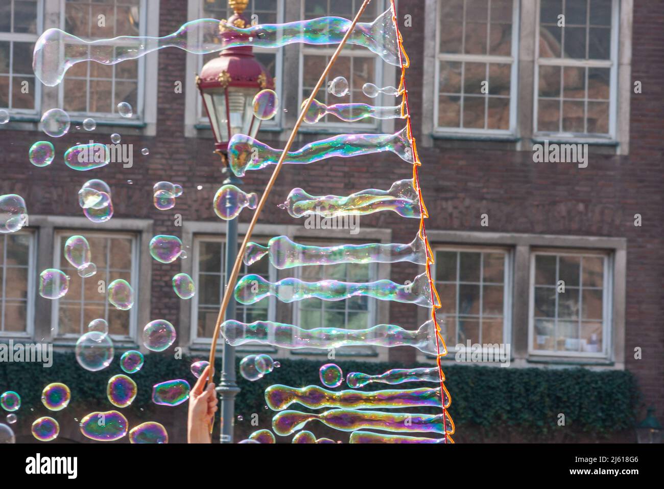Gigantic soap bubbles shimmer and glimmer in the sun as colorful kids ...