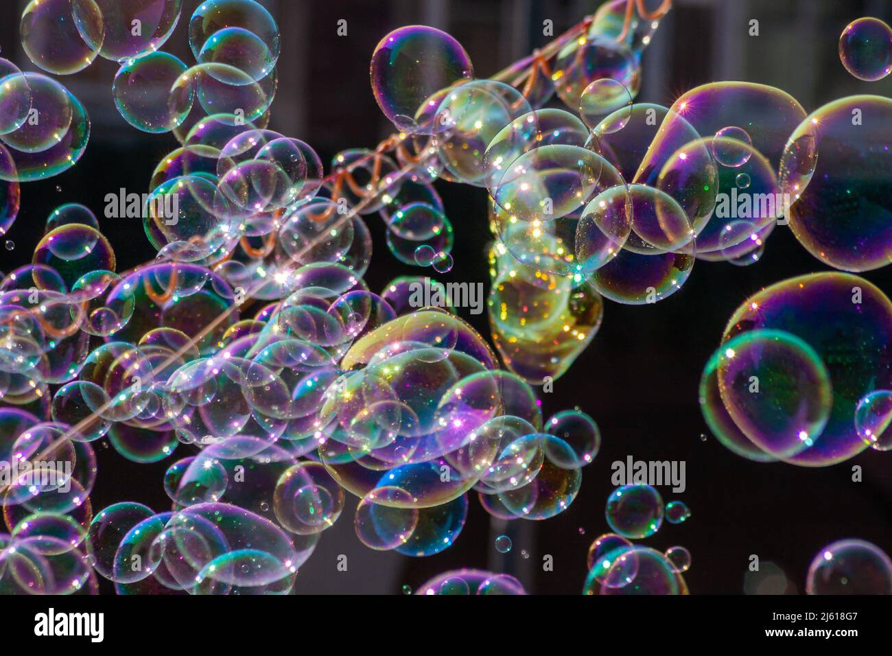 Gigantic soap bubbles shimmer and glimmer in the sun as colorful kids ...