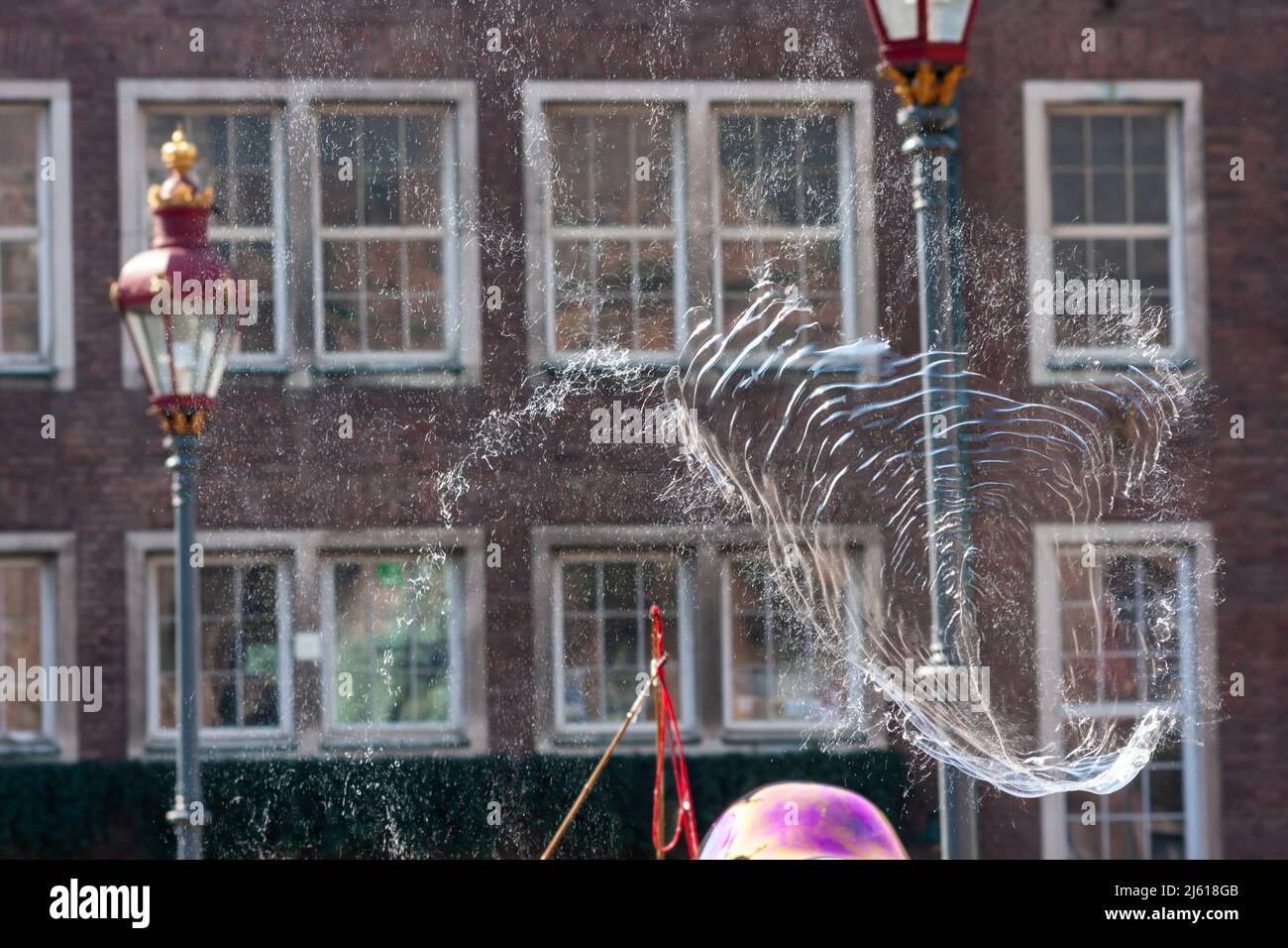Gigantic soap bubbles shimmer and glimmer in the sun as colorful kids ...