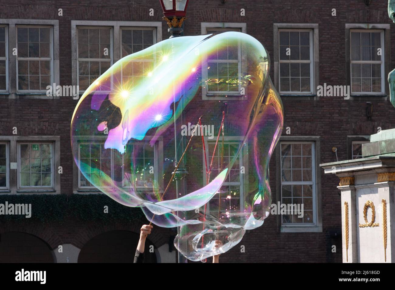 Gigantic soap bubbles shimmer and glimmer in the sun as colorful kids ...