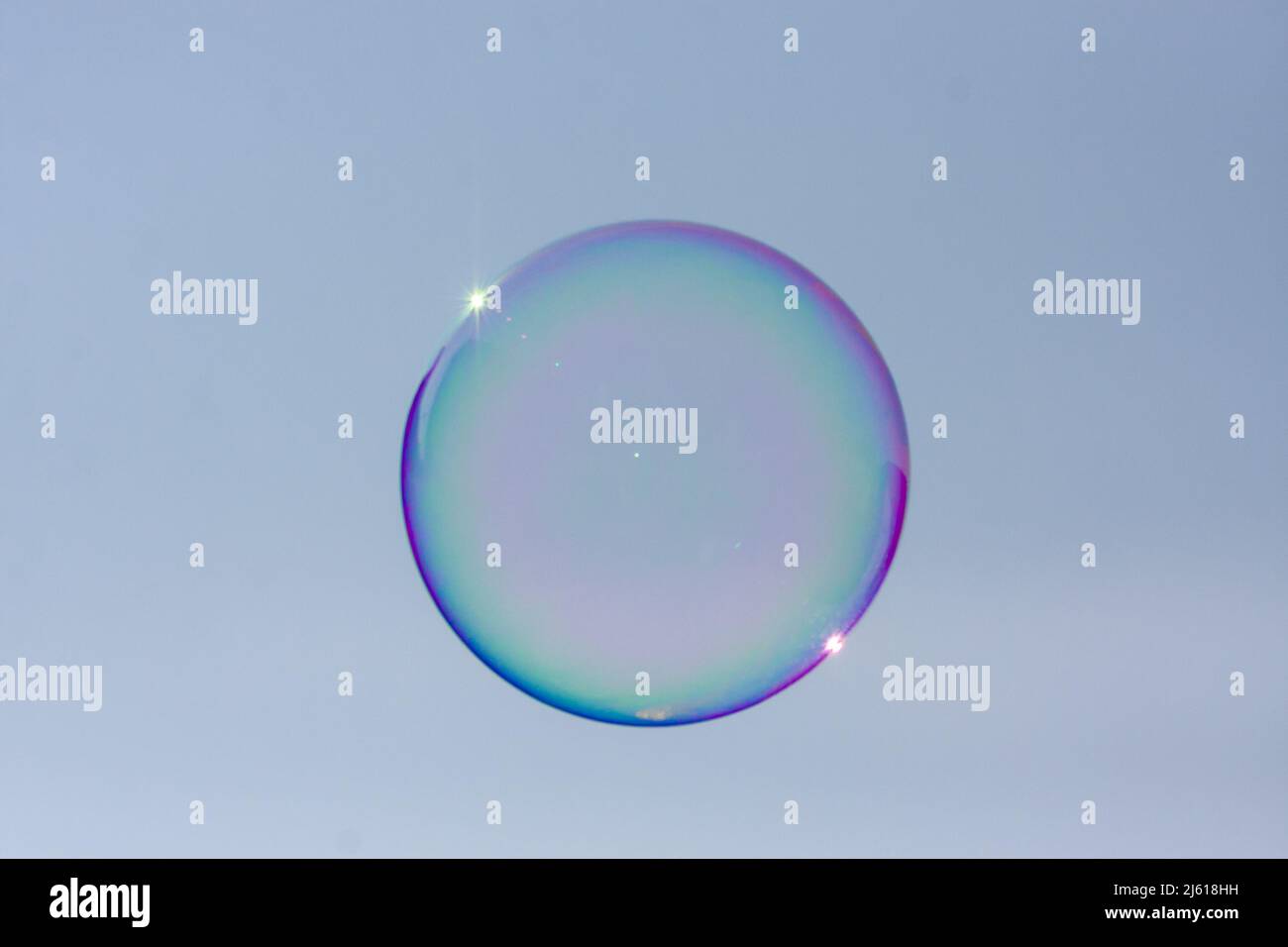 Gigantic soap bubbles shimmer and glimmer in the sun as colorful kids ...