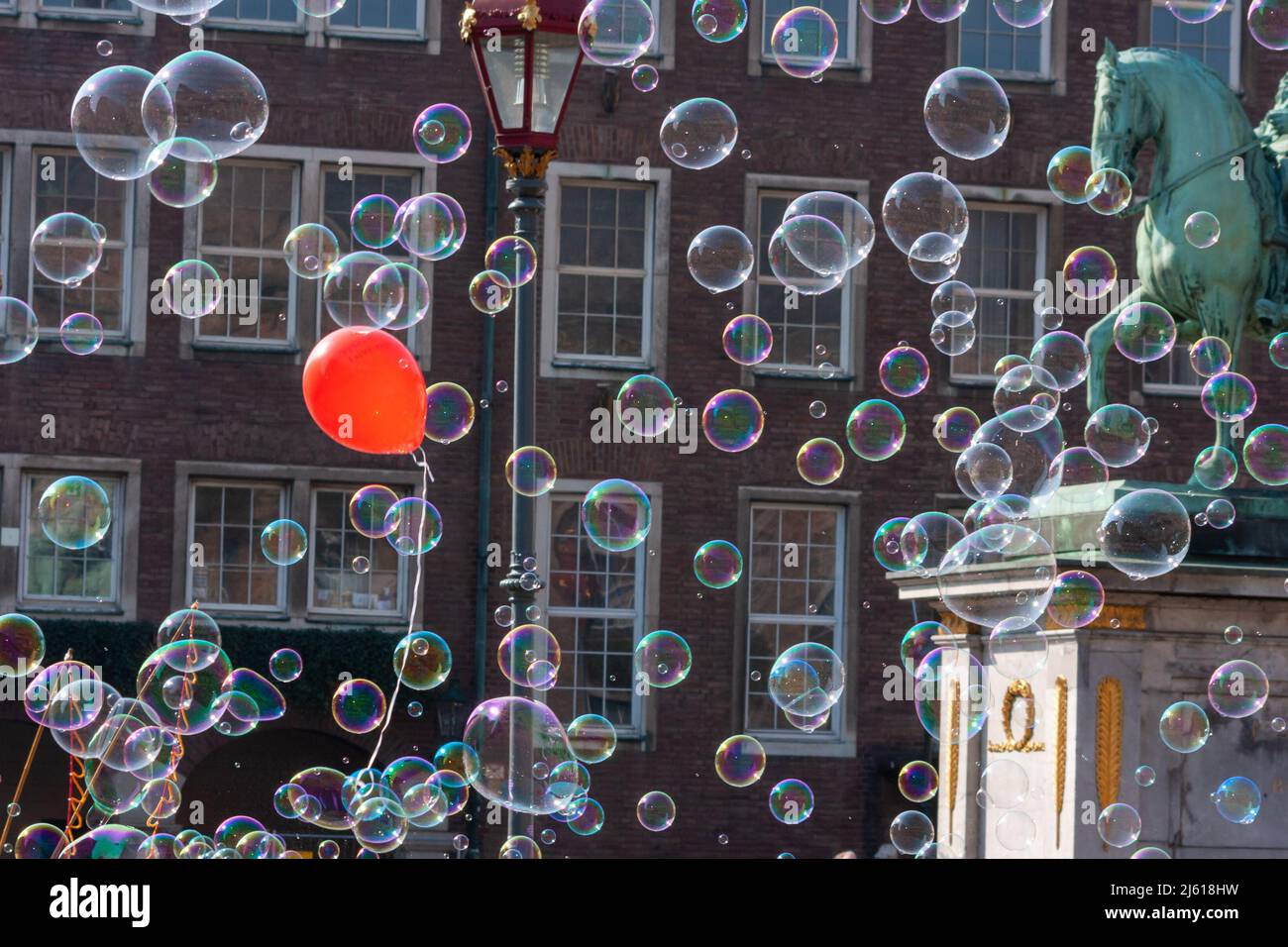 Gigantic soap bubbles shimmer and glimmer in the sun as colorful kids ...