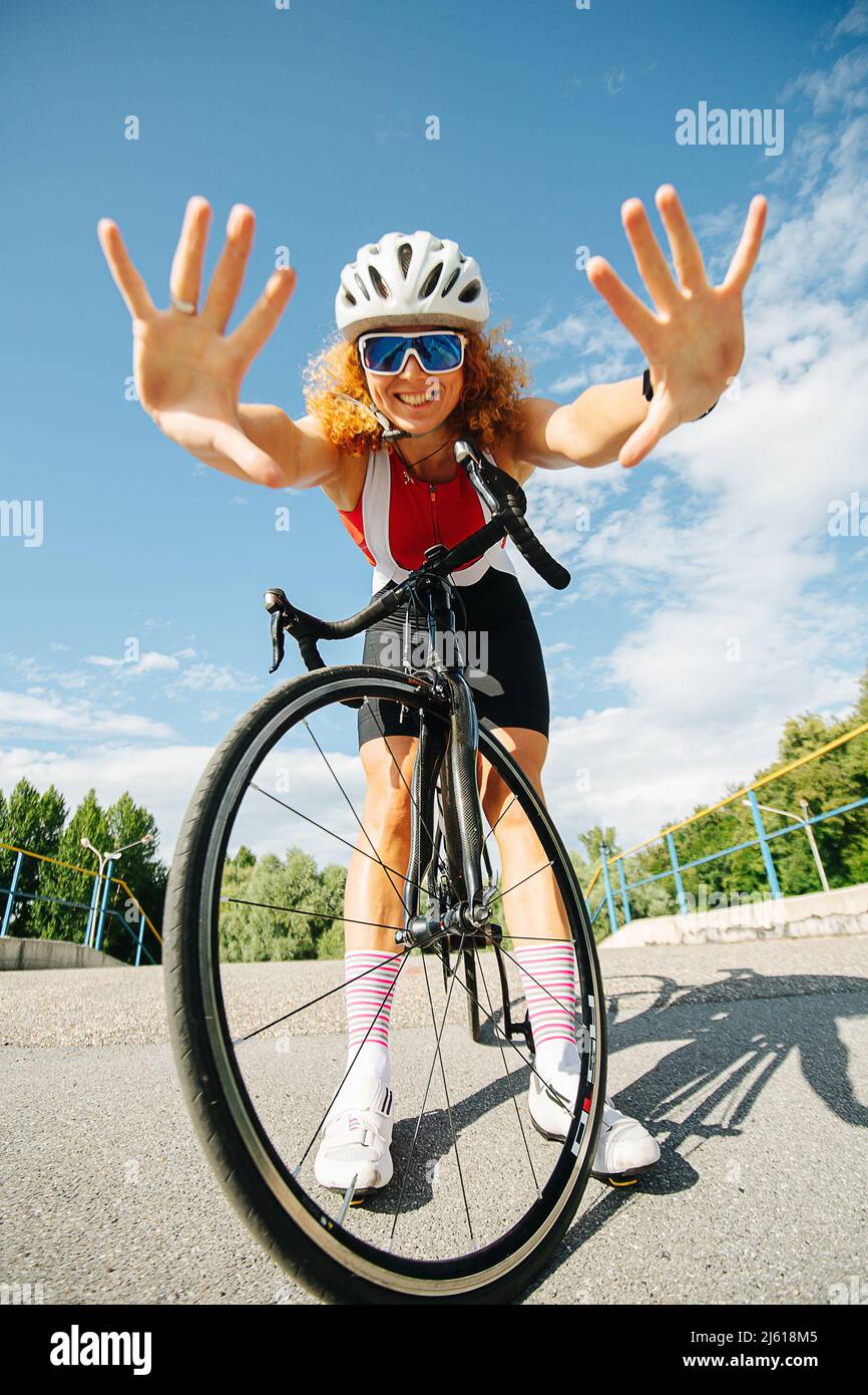 Close up low angle image of a woman with curly hair in a helmet waving ...