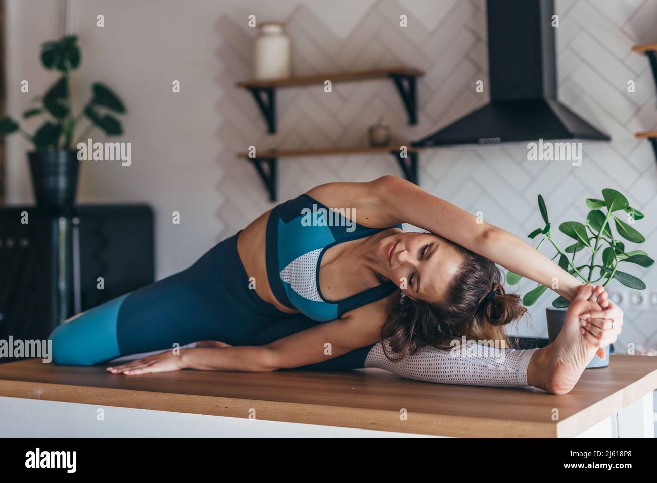 Fit woman practicing flexibility in side bend pose Stock Photo - Alamy