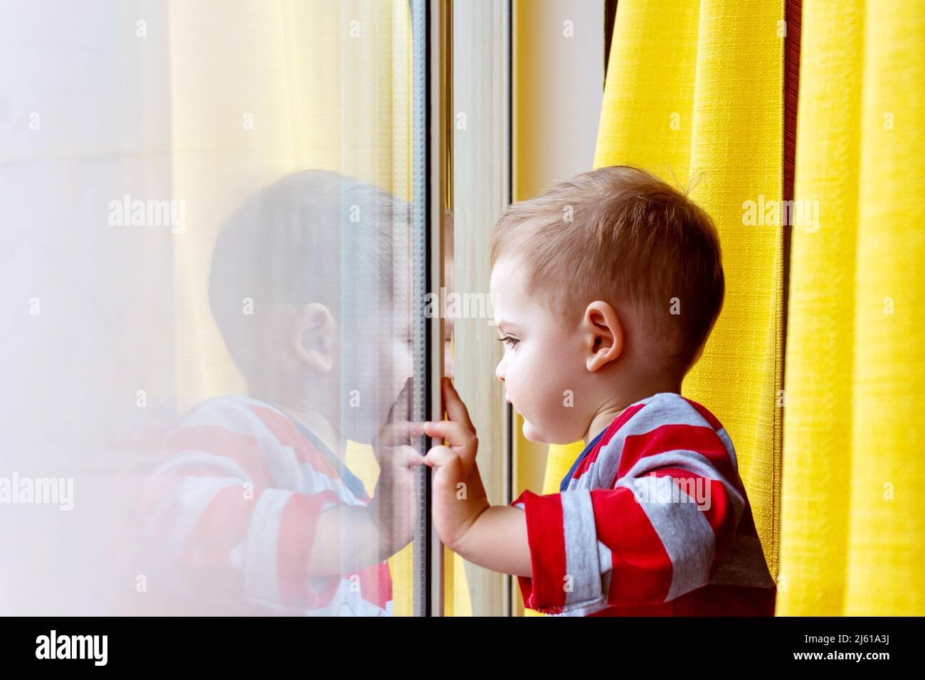 Little boy looking out the window. Close-up Stock Photo - Alamy