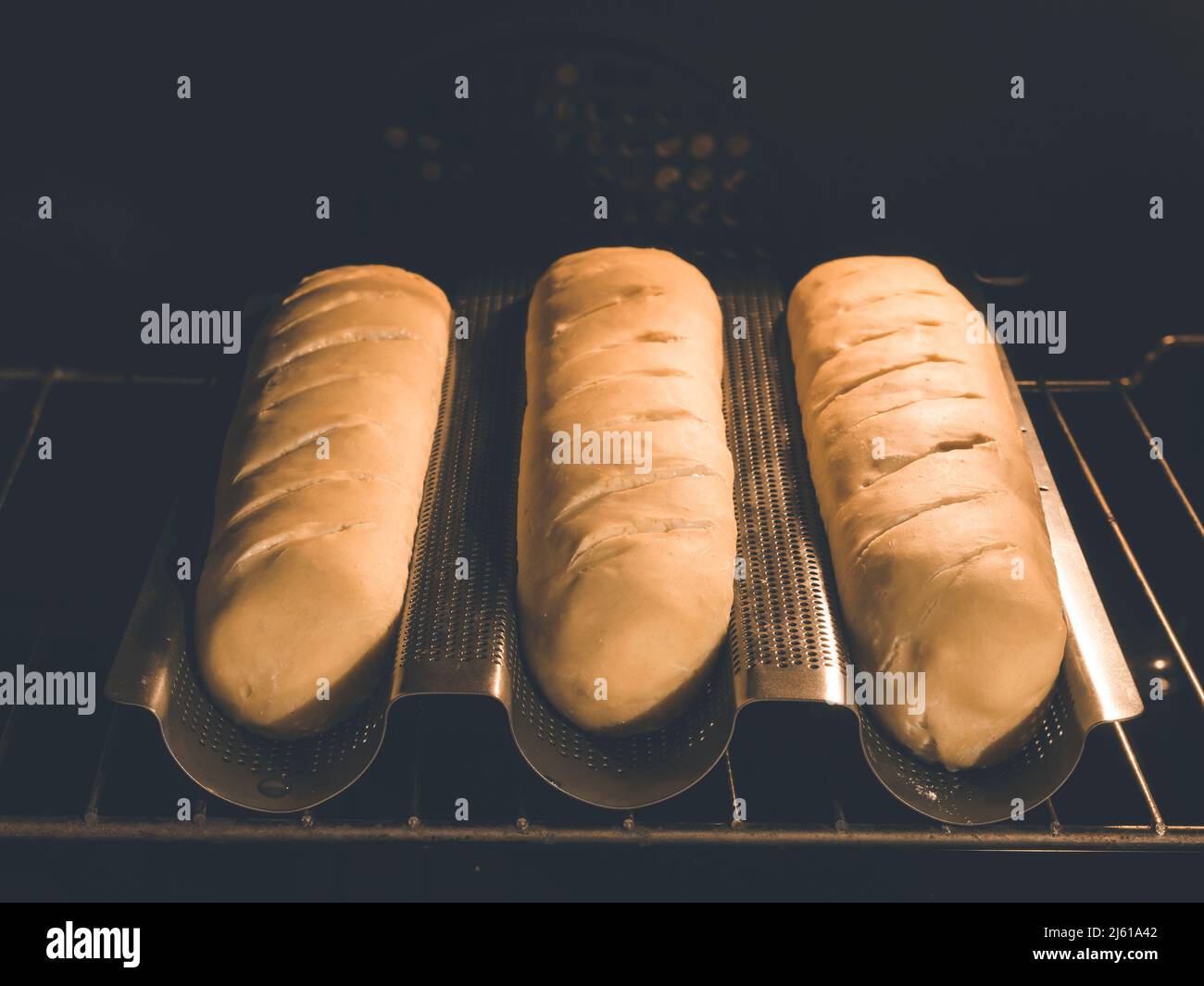 image shows 3 homemade baguettes or french bread in special baguette ...