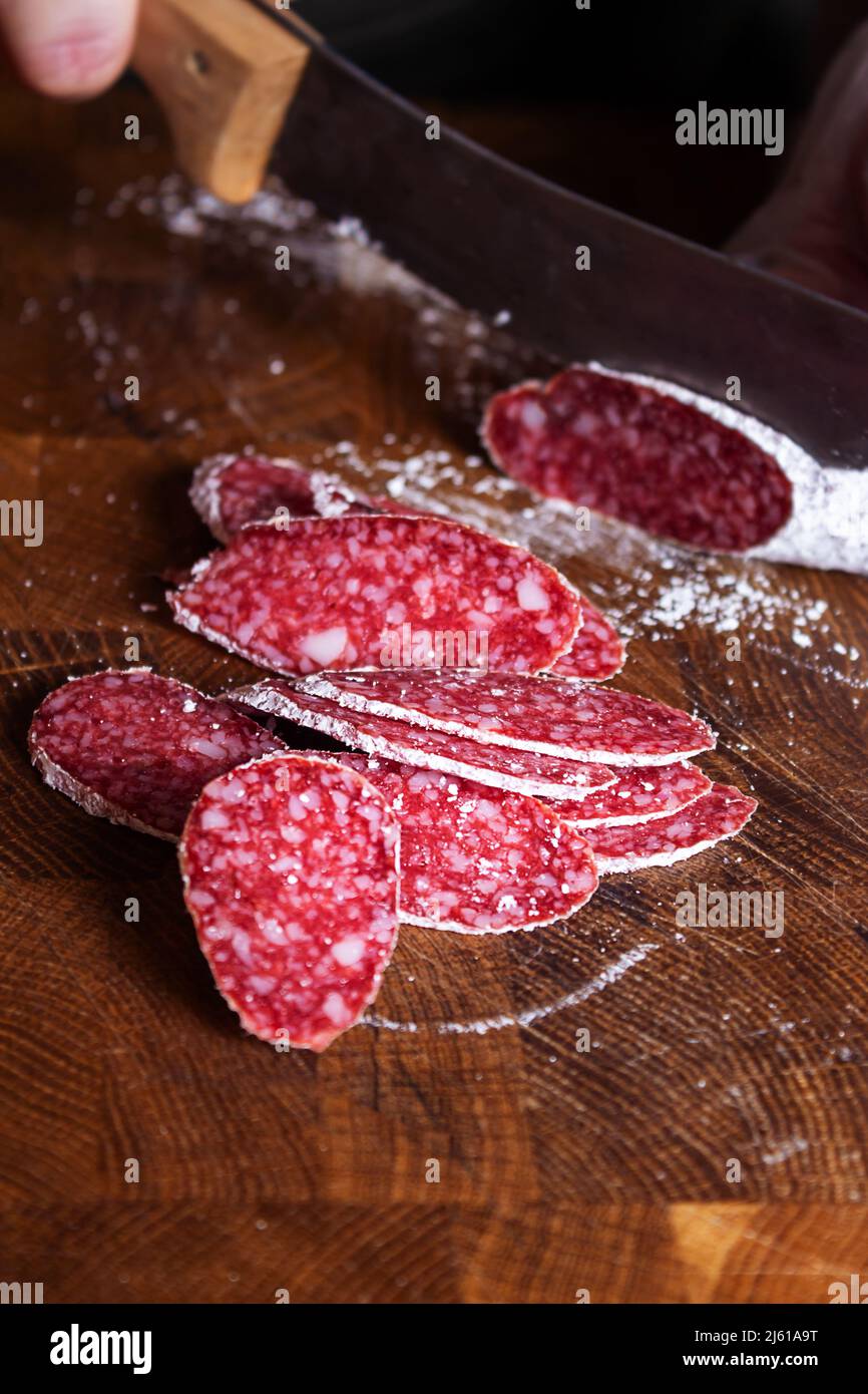 Close-up of sliced salami on wooden board Stock Photo - Alamy
