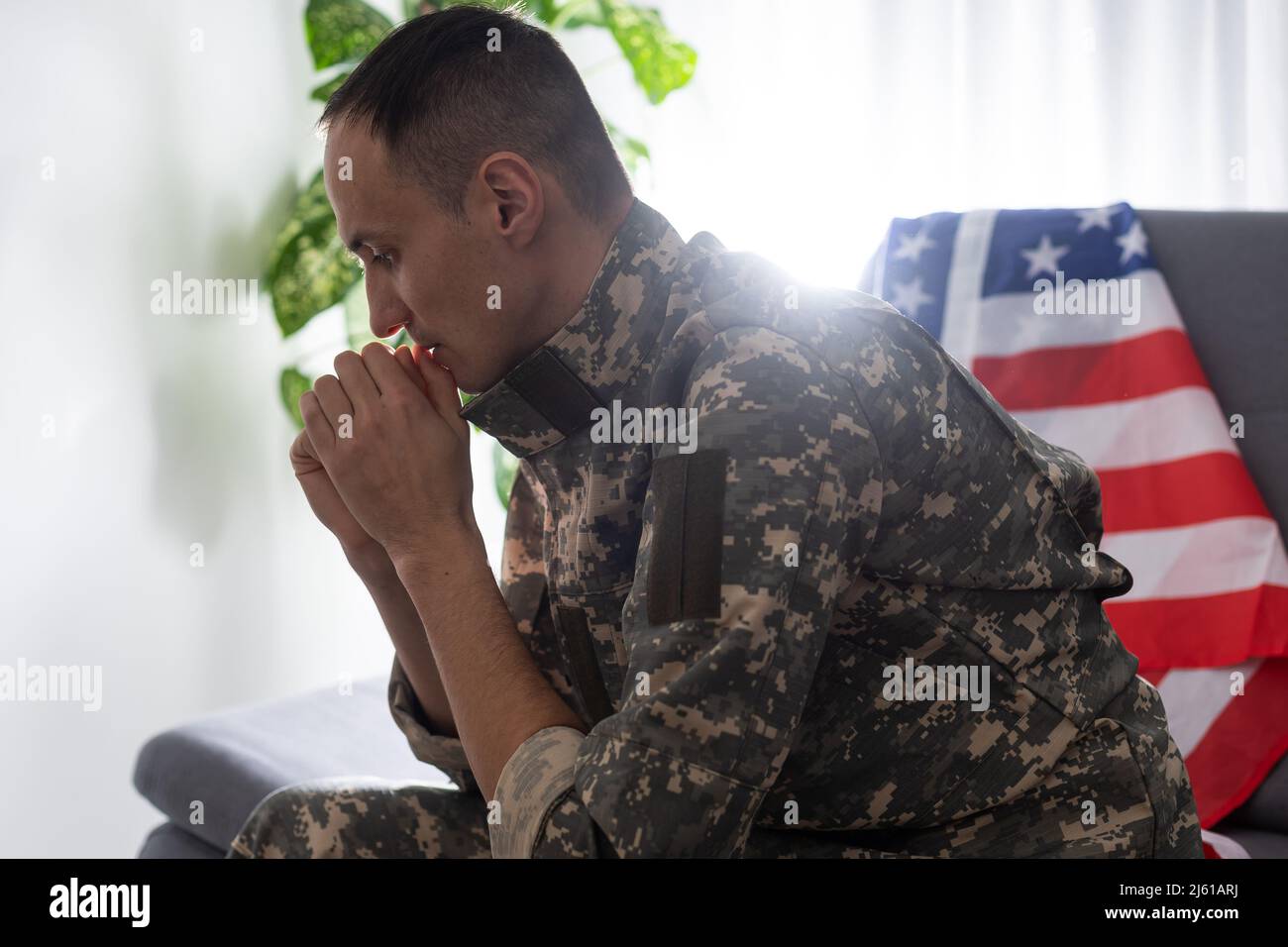sad soldier in camouflage uniform holding military tag in clenched ...