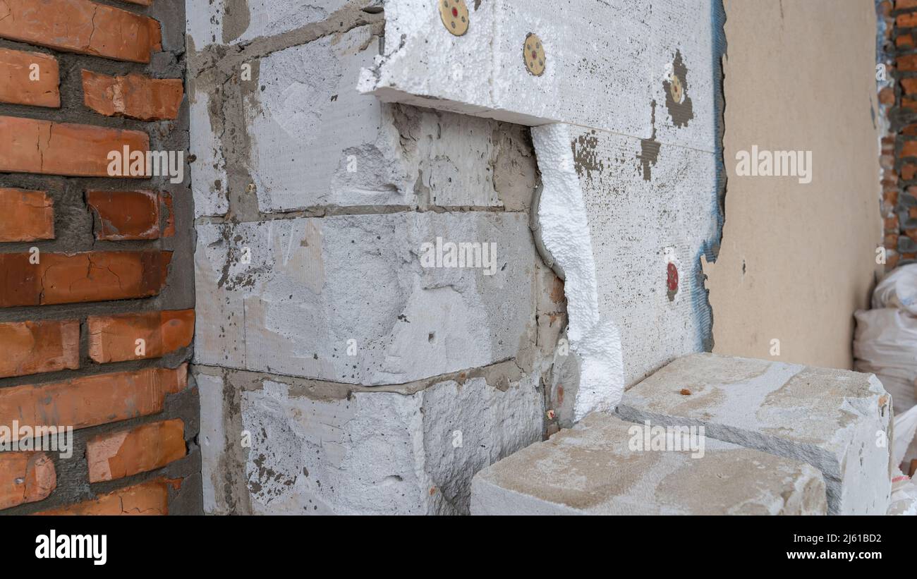 Ruined corner of the house close-up. Aerated concrete and red brick ...